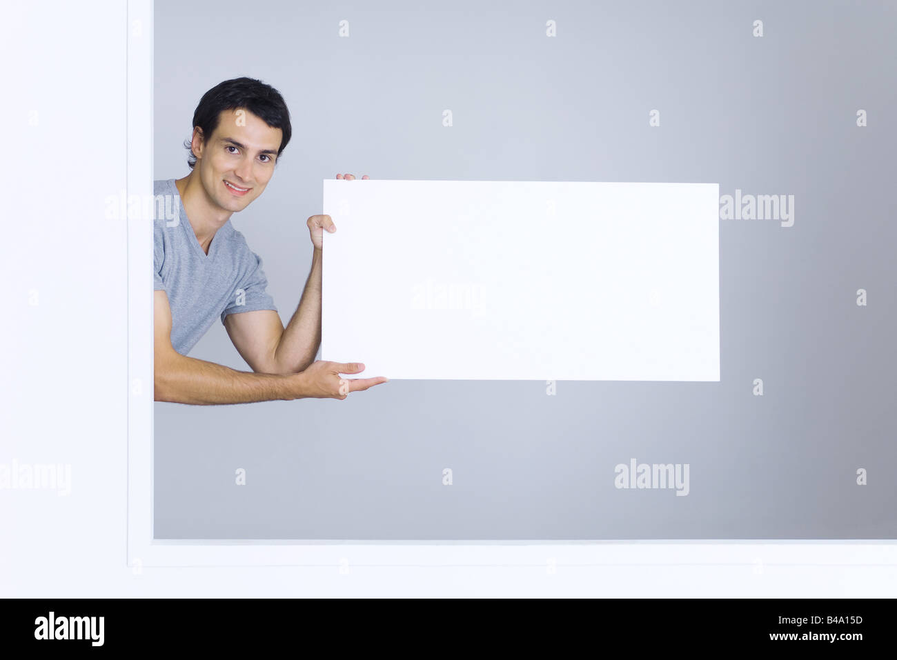 Man holding blank sign, smiling at camera Stock Photo - Alamy