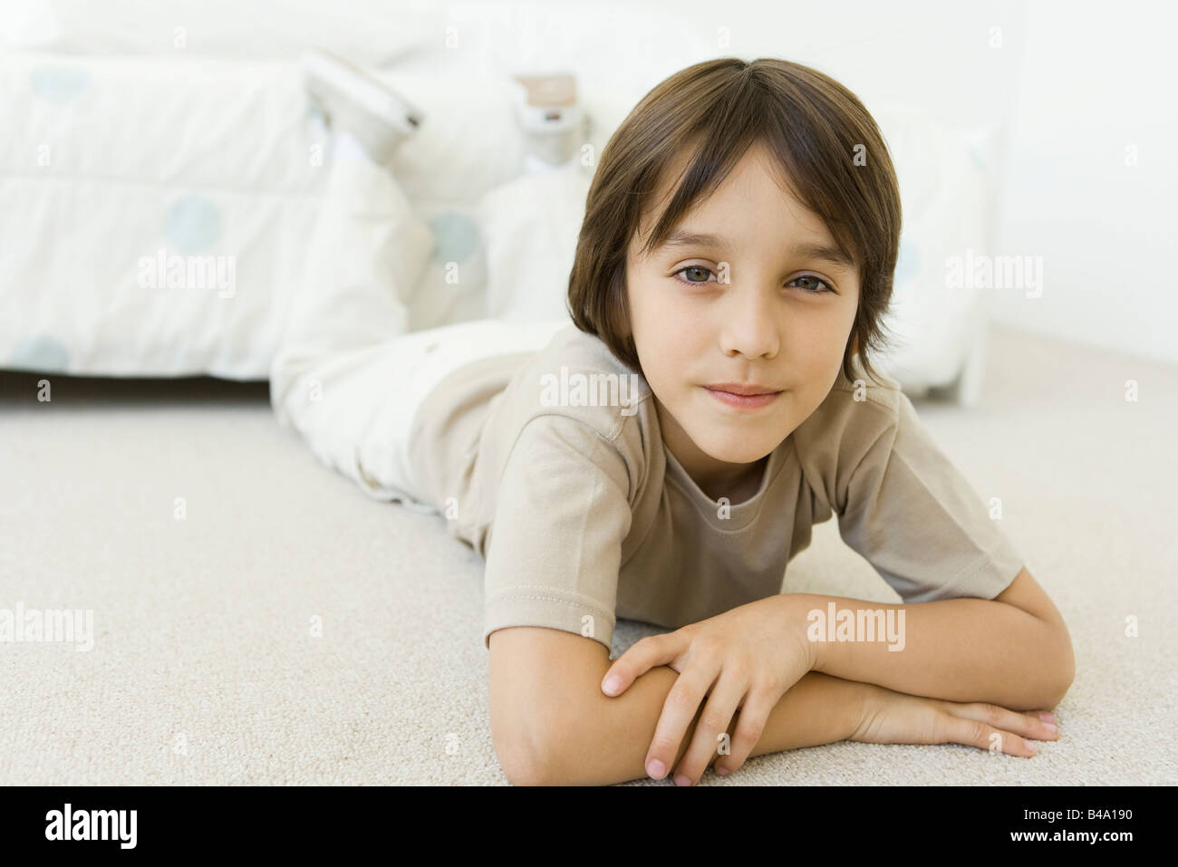 Boy lying on the floor in bedroom, smiling at camera Stock Photo - Alamy
