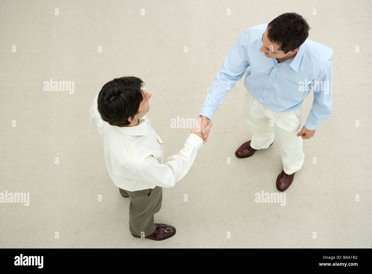 Two men shaking hands, overhead view Stock Photo - Alamy