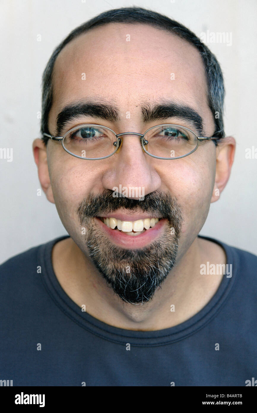 Portrait of a man of Hispanic Ethnicity He is wearing a gray grey t ...