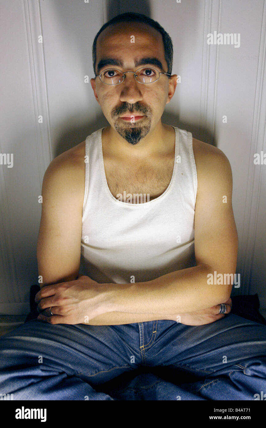 Portrait of a man of Hispanic Ethnicity He is sitting and is wearing ...