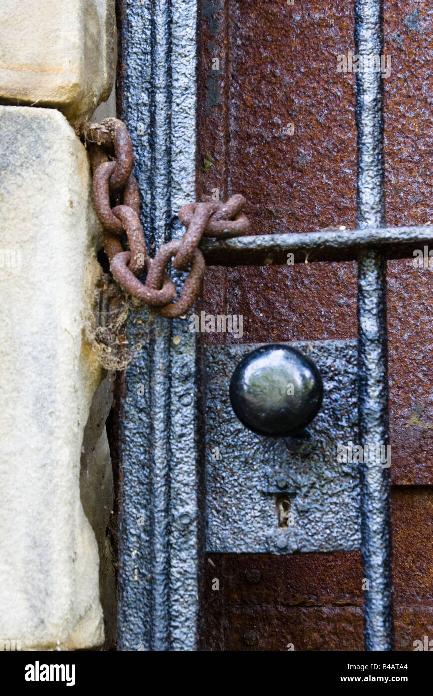 Rusty locked door to a crypt protected with a door of black bars locked ...