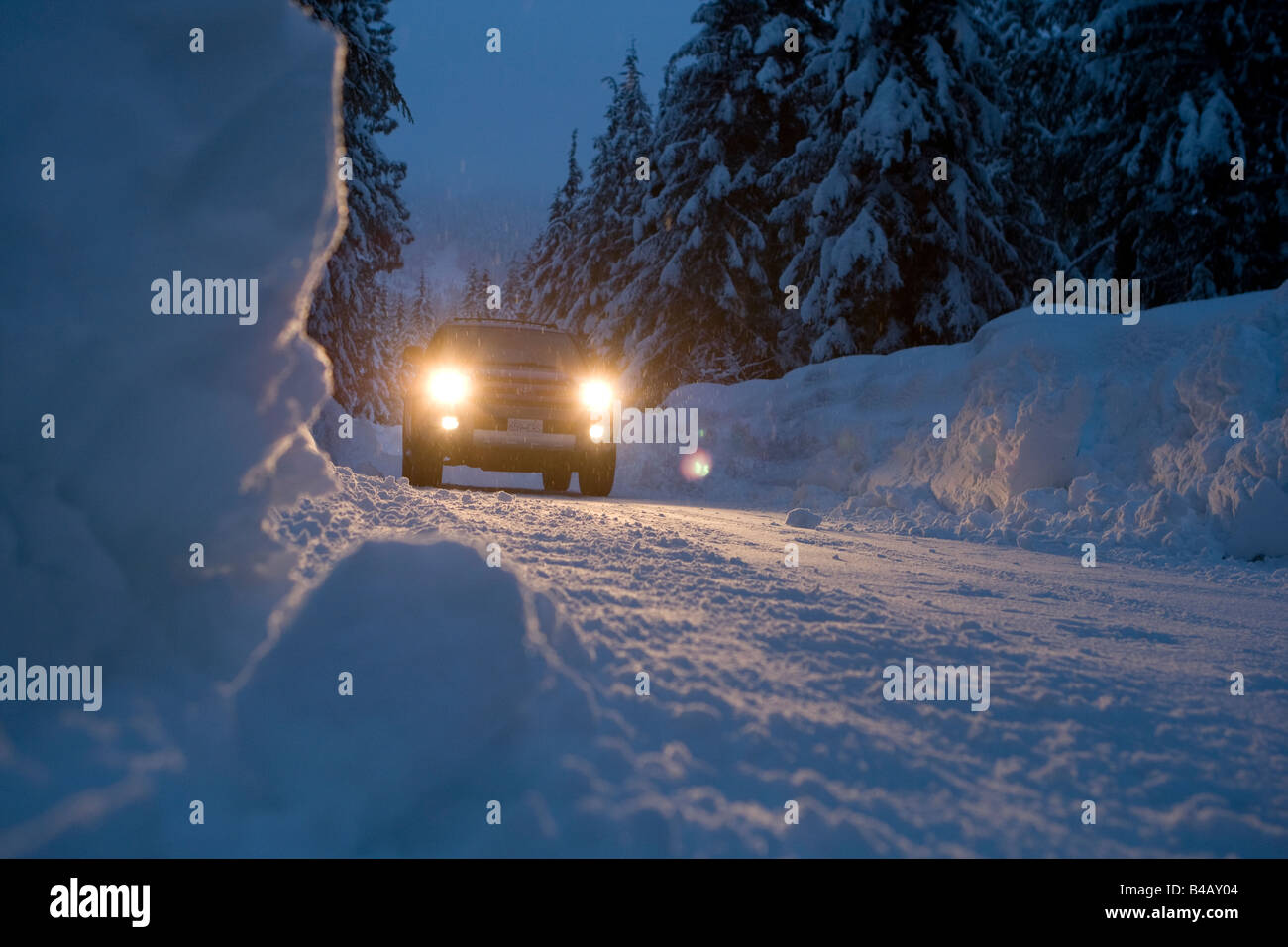 truck at night on a snowy road with lights on Stock Photo - Alamy