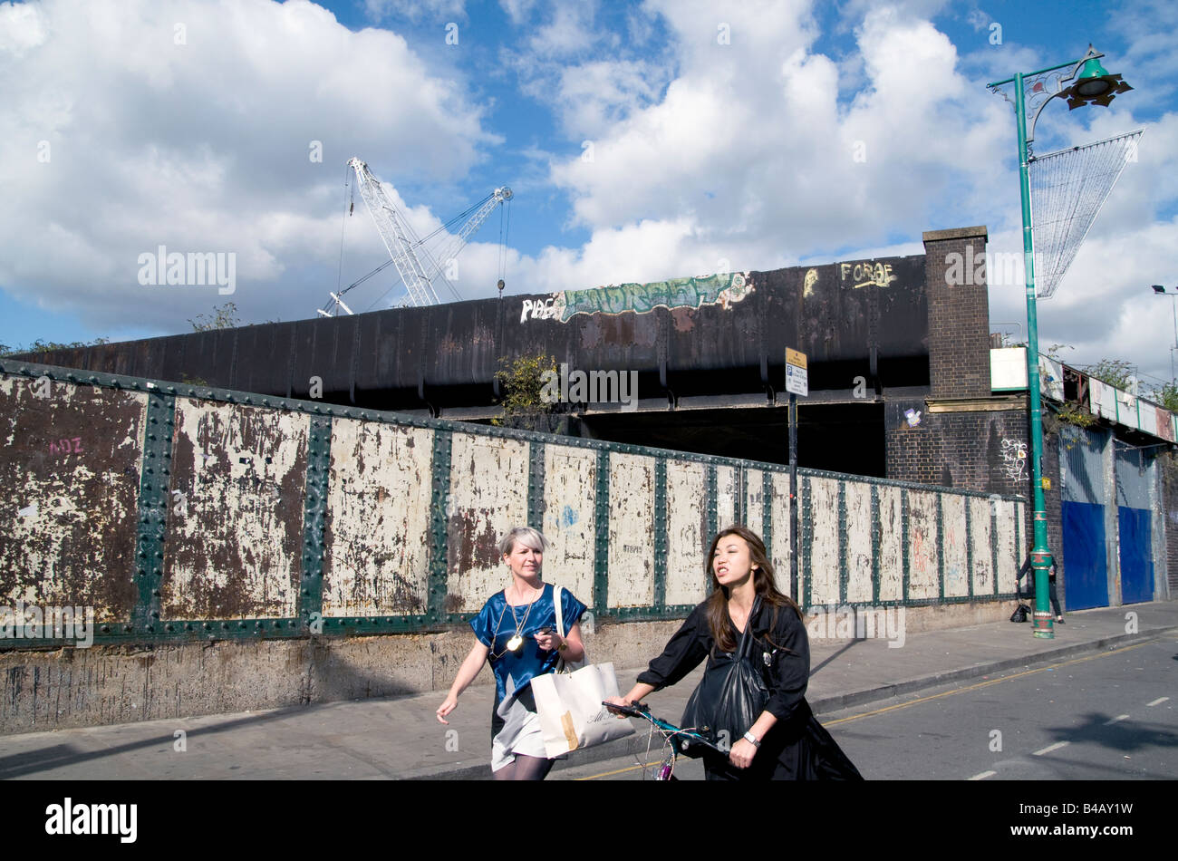 UK. Walking on Brick Lane by Underground bridge for new Tube station ...