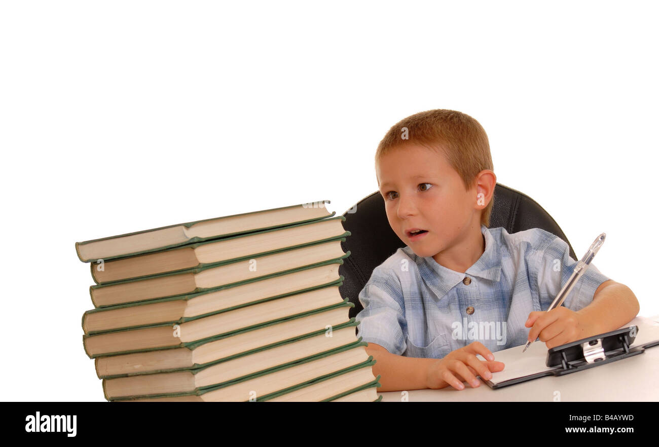 Young boy studying with a large pile of books Stock Photo - Alamy