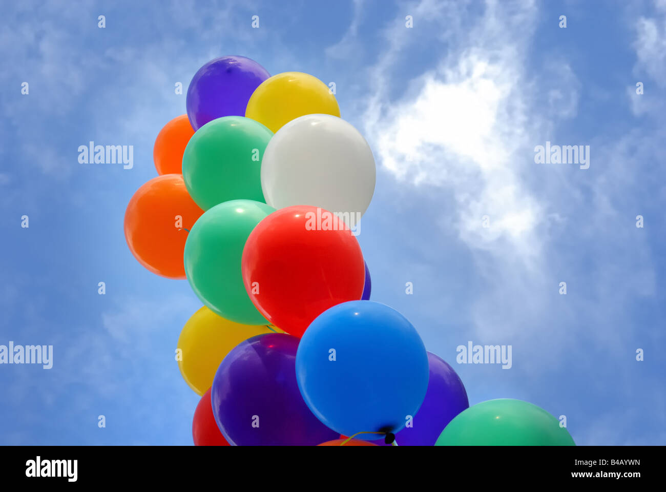 A group of balloons in rainbow colors float against a cloudy sky Stock ...