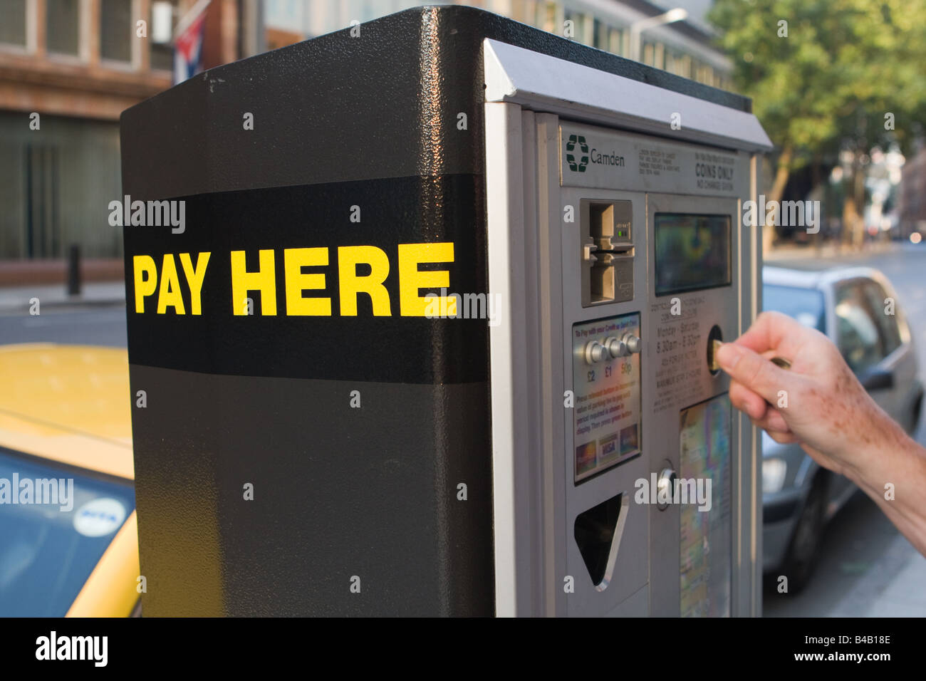 Man paying money into a parking permit ticket machine Stock Photo - Alamy