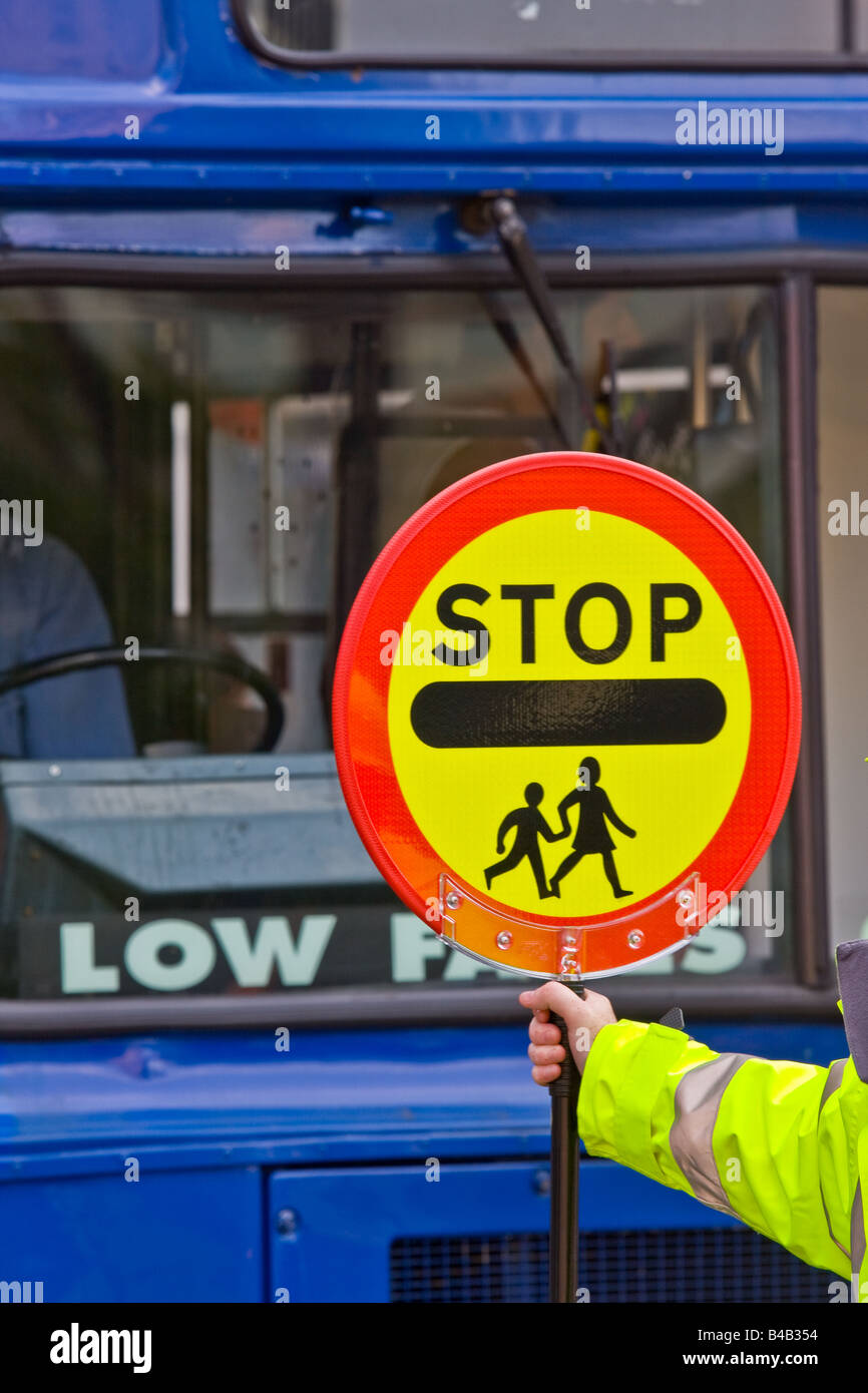 A Crossing Guard stops a bus on a street in Manchester, England Stock ...