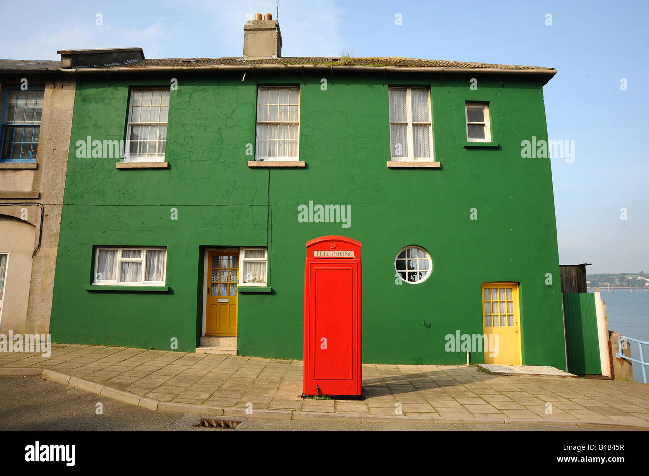 House, green with red telephone box and yellow door Stock Photo - Alamy