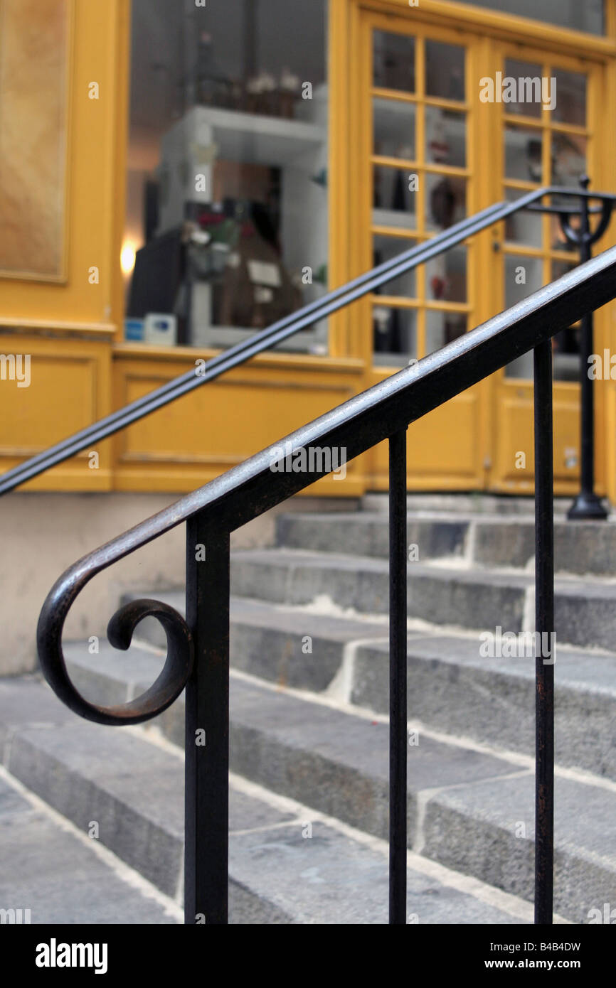 iron black handrail on a step with yellow window and door on the back ...