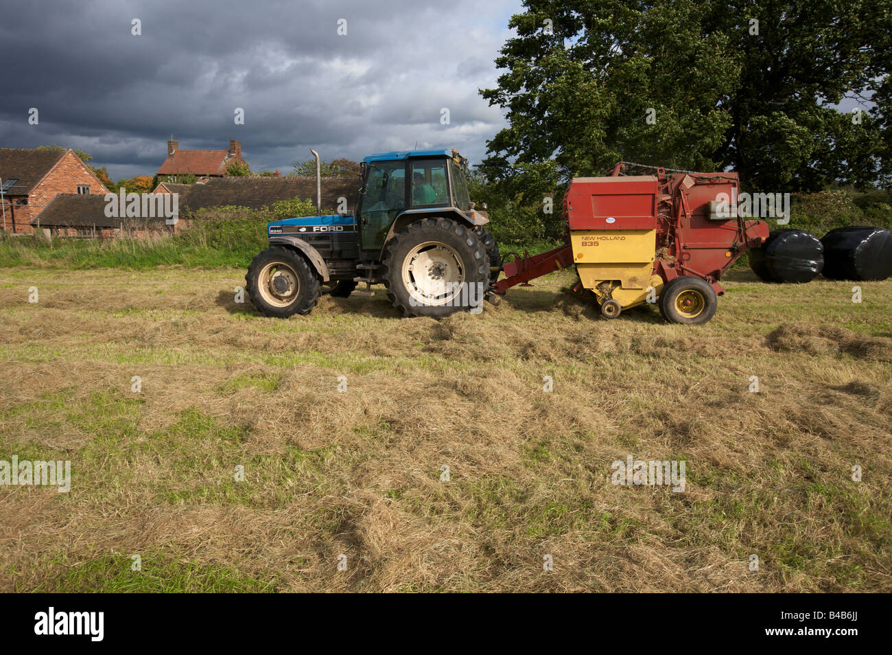 Ford Tractor With Round Baler UK Stock Photo - Alamy