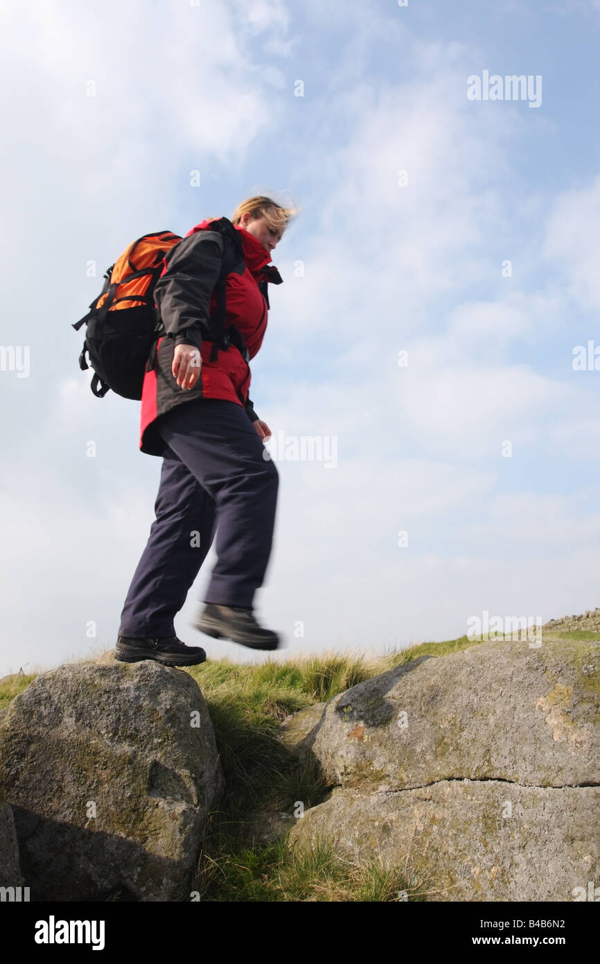 Low Level Shot of Female Hill Walker Stepping Across Boulders With ...