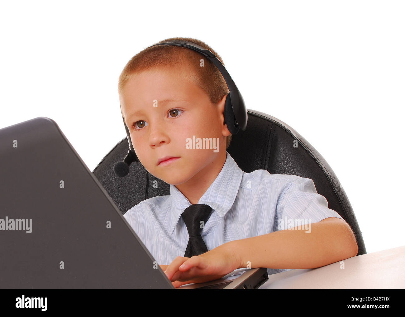 Boy at computer with headset on Stock Photo - Alamy