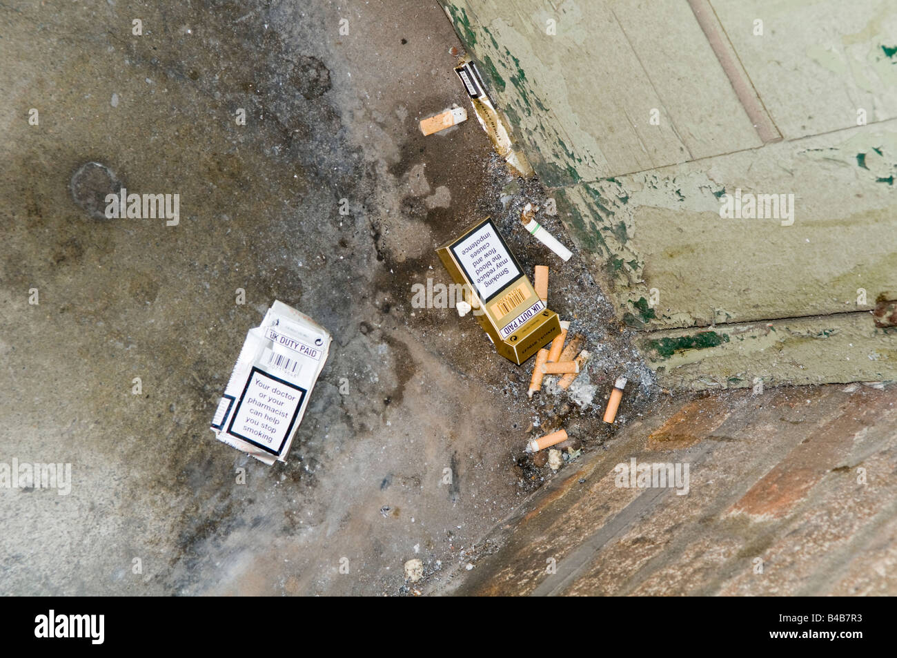 Pile of discarded cigarette butts in a doorway Stock Photo - Alamy