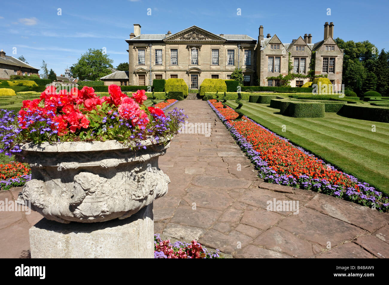 A flower urn in Coombe Abbey garden with walkway to the house Stock ...