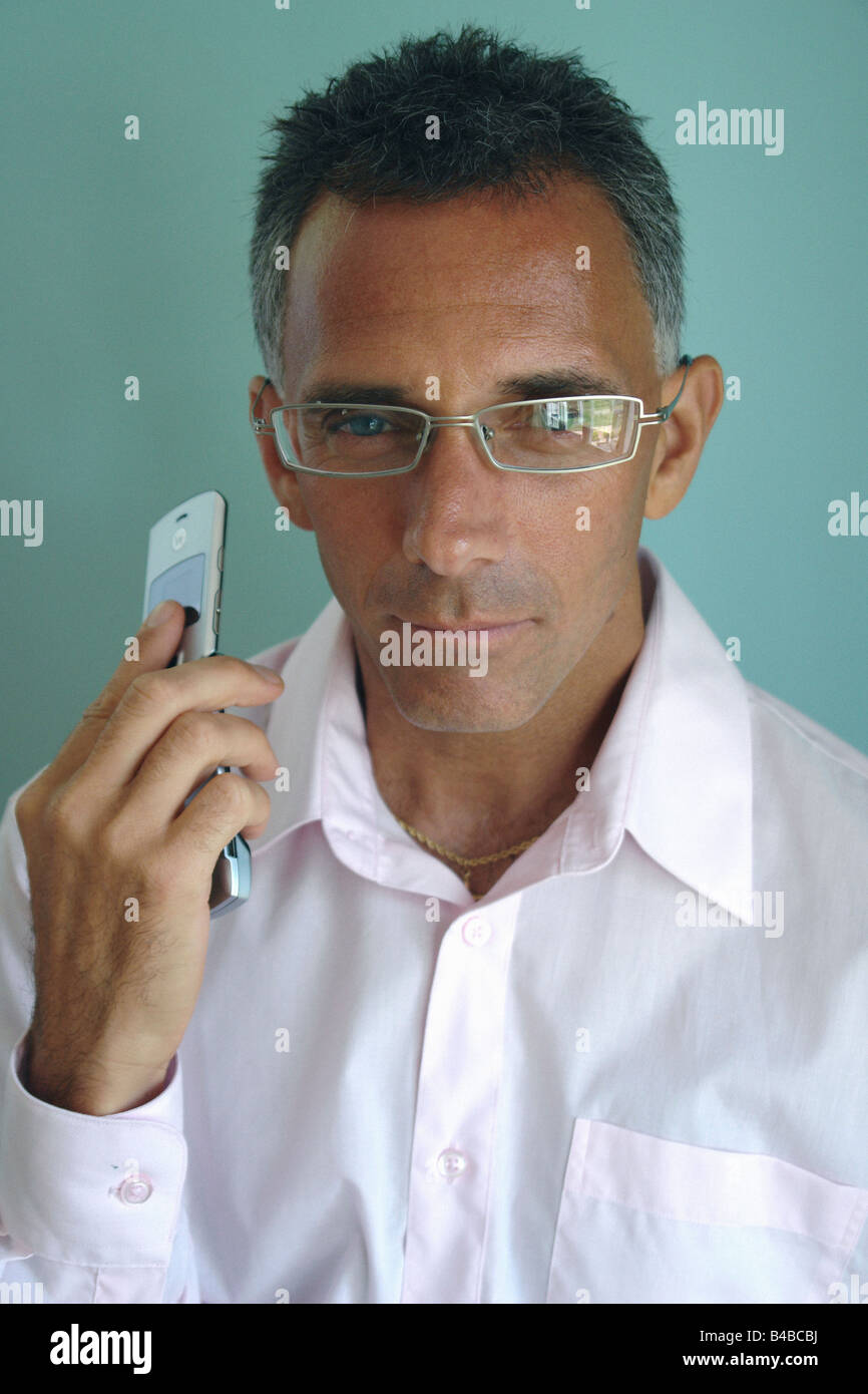Baby Boomer Aged Man Holding a Cellular Mobile Phone He is Wearing ...