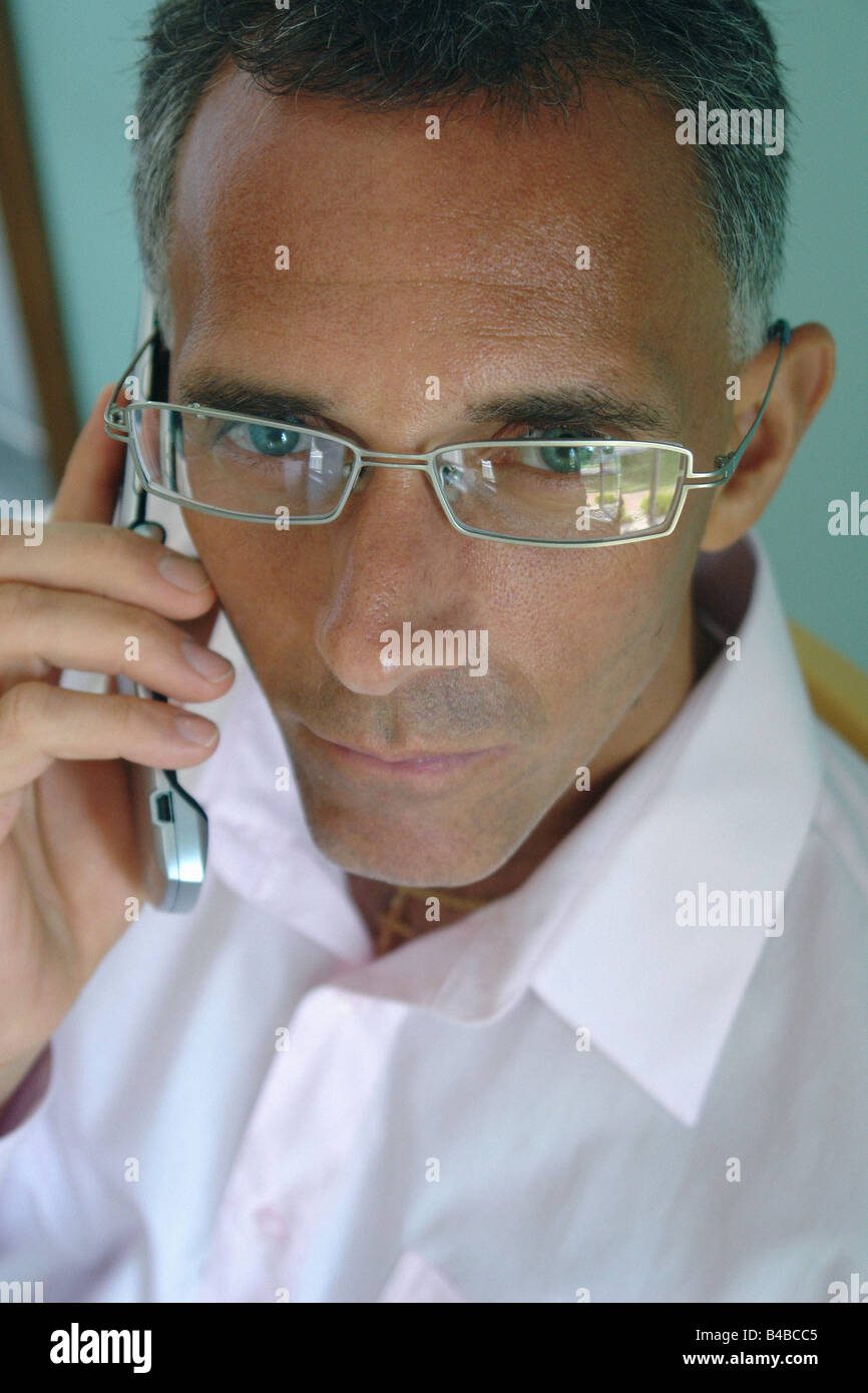 Baby Boomer Aged Man Holding a Cellular Mobile Phone He is Wearing ...