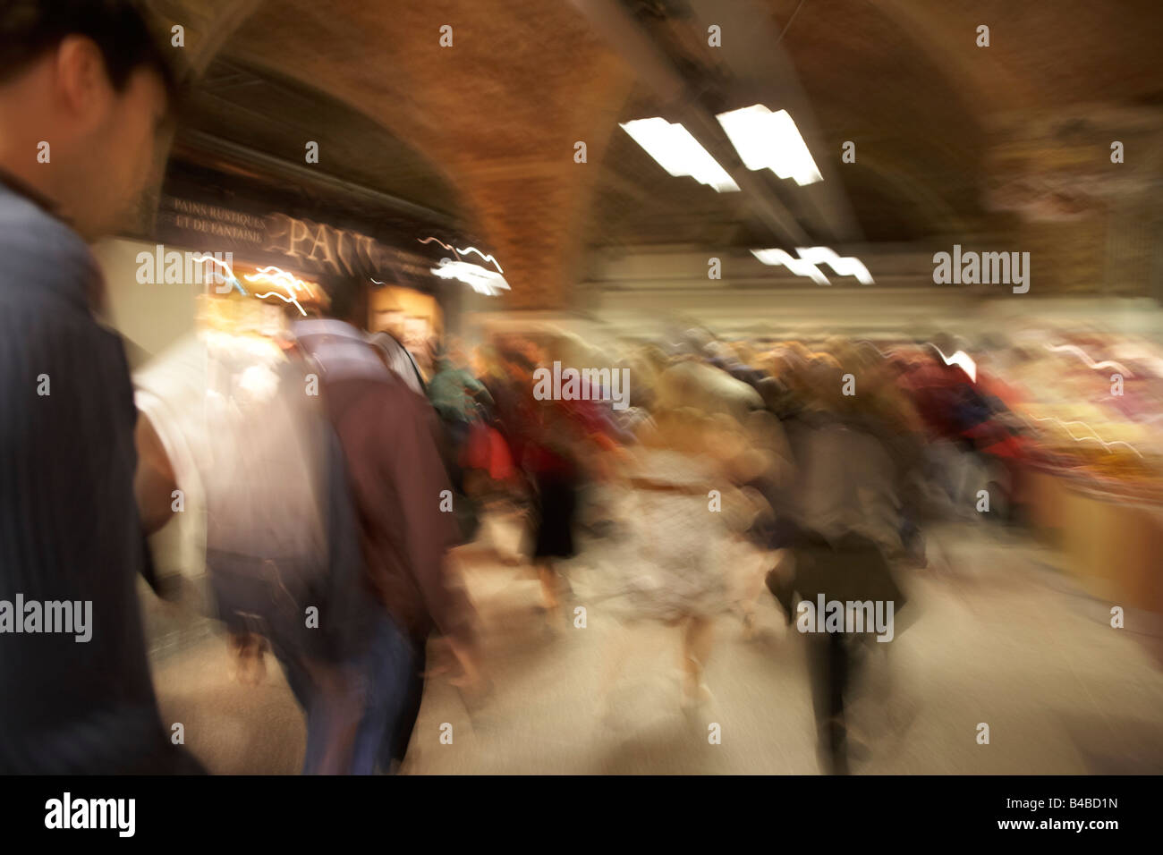 Rush hour train commuters blur through a mainline Station walking en ...