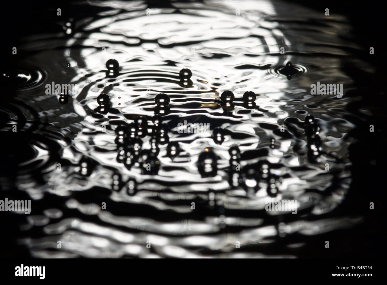 Three water spheres floating on ripple water round circle black white ...