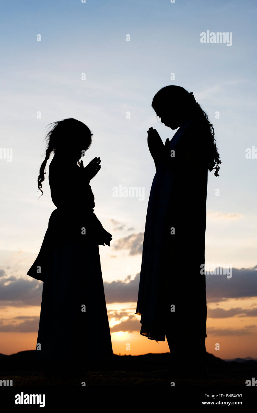 Indian sisters praying at sunset silhouette. Andhra Pradesh, India ...