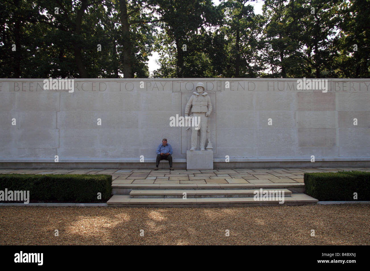 A man sits reading beside a Coastguard memorial statue on the Wall of ...