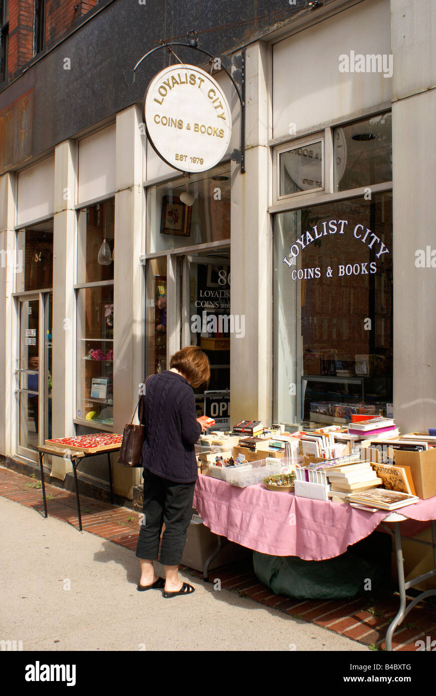 Woman looking at books outside a bookstore in the city of Saint John ...