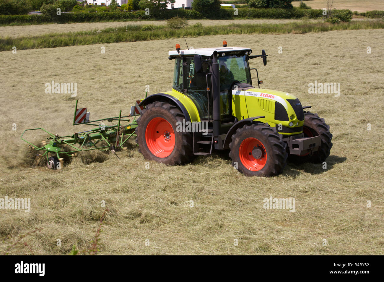 Turning Hay with a Claas Ares 697 ATZ Tractor UK Stock Photo - Alamy