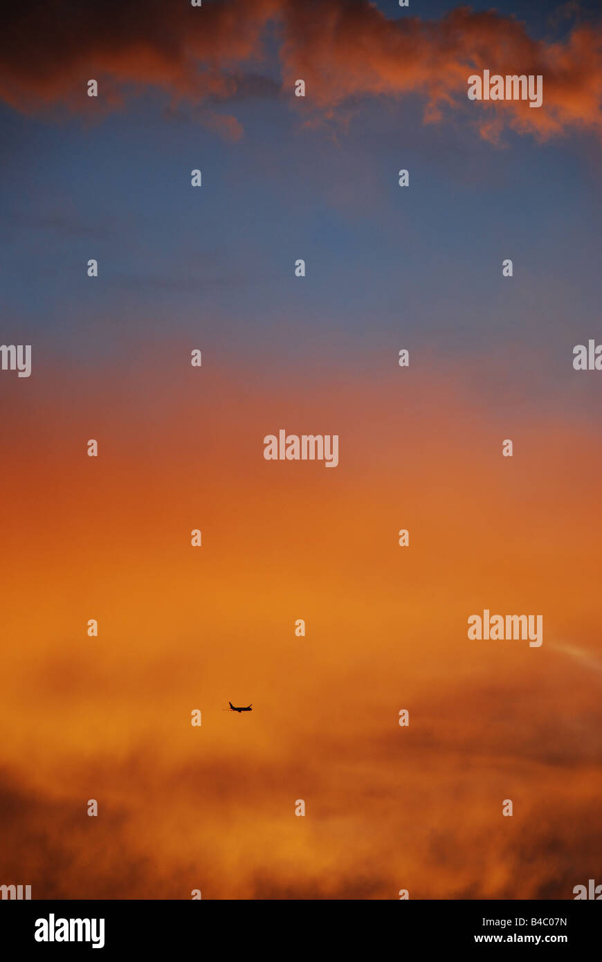 Sunset sky with airplane flying across in far distance Stock Photo - Alamy