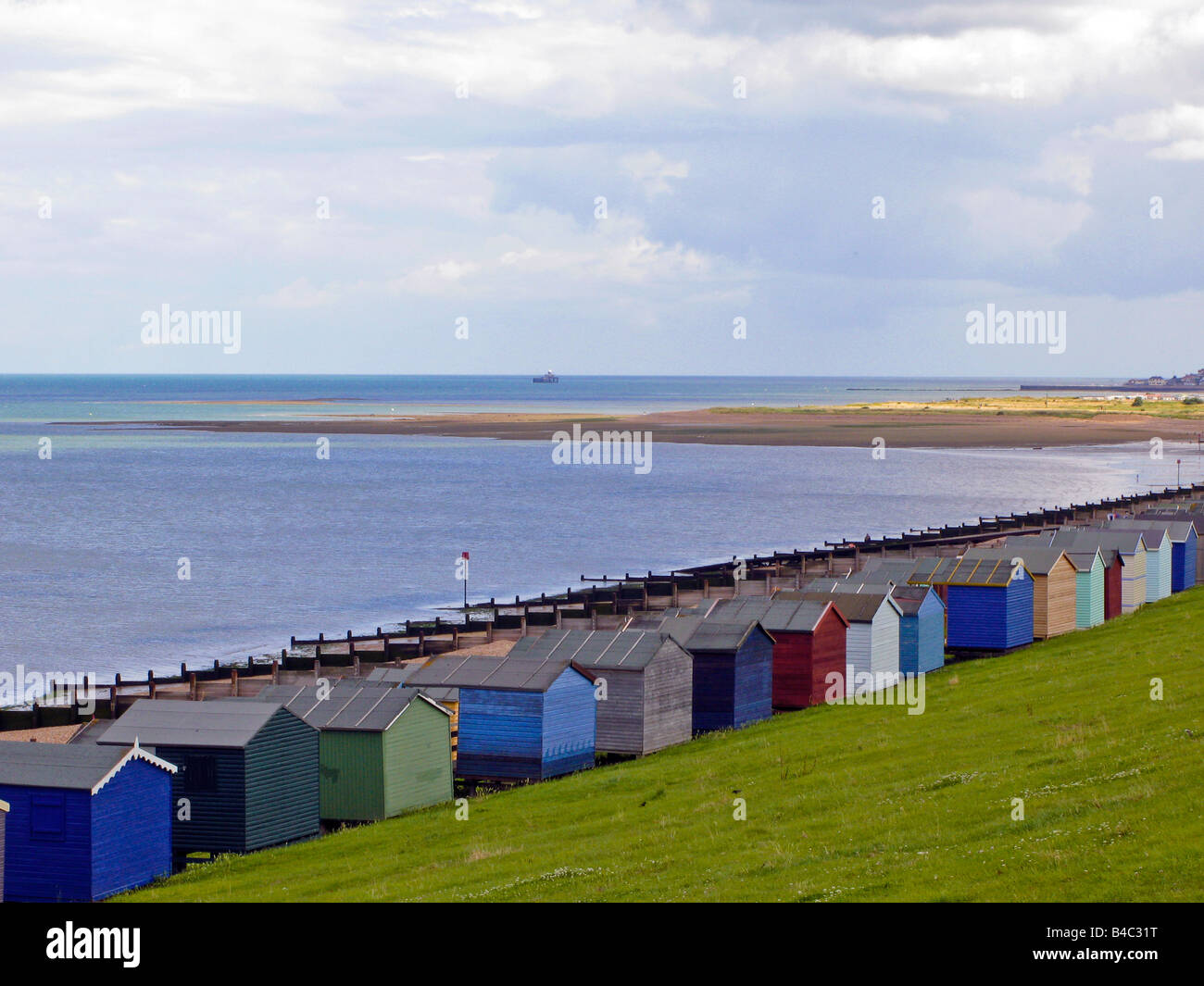 A view of a row beach huts side by side on the beach front at ...