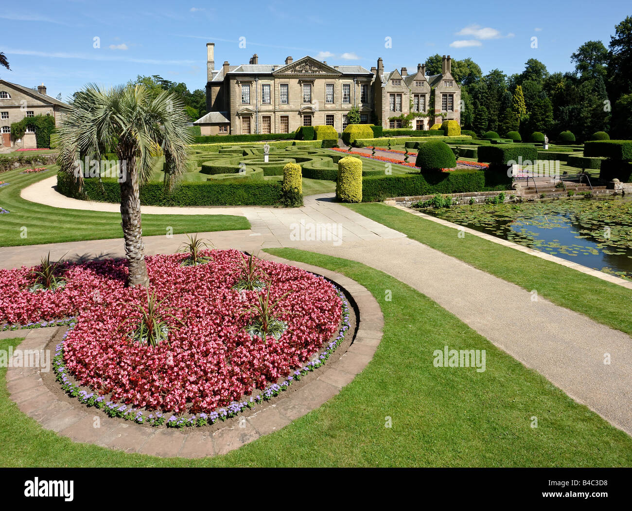 A view of flower beds in Coombe Abbey garden with walkway to the house ...