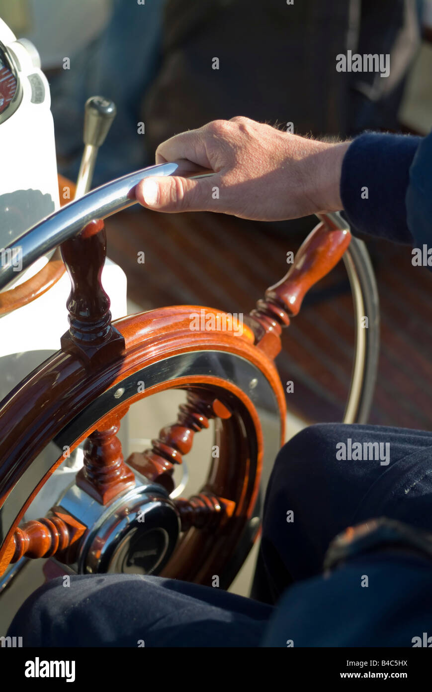 a man taking a rudder wheel and a compass Stock Photo - Alamy