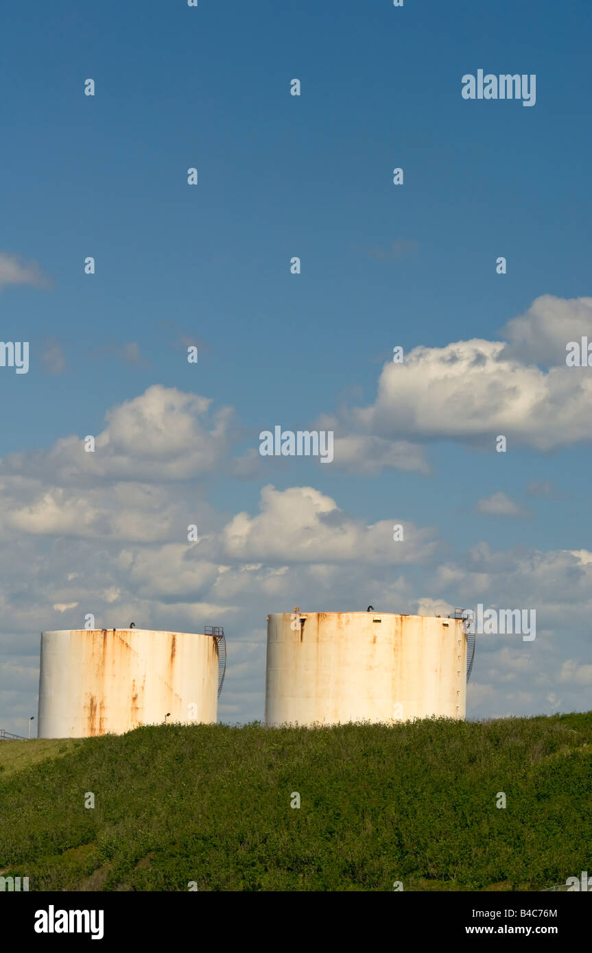 Two oil tanks on a green hill with some rust showing Stock Photo - Alamy
