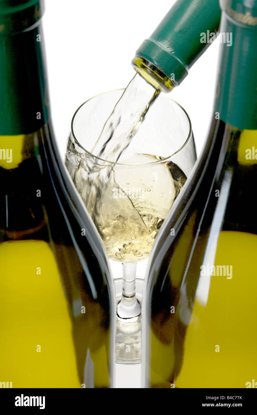 Still life. Pouring a glass of french white chardonay wine with bottles ...
