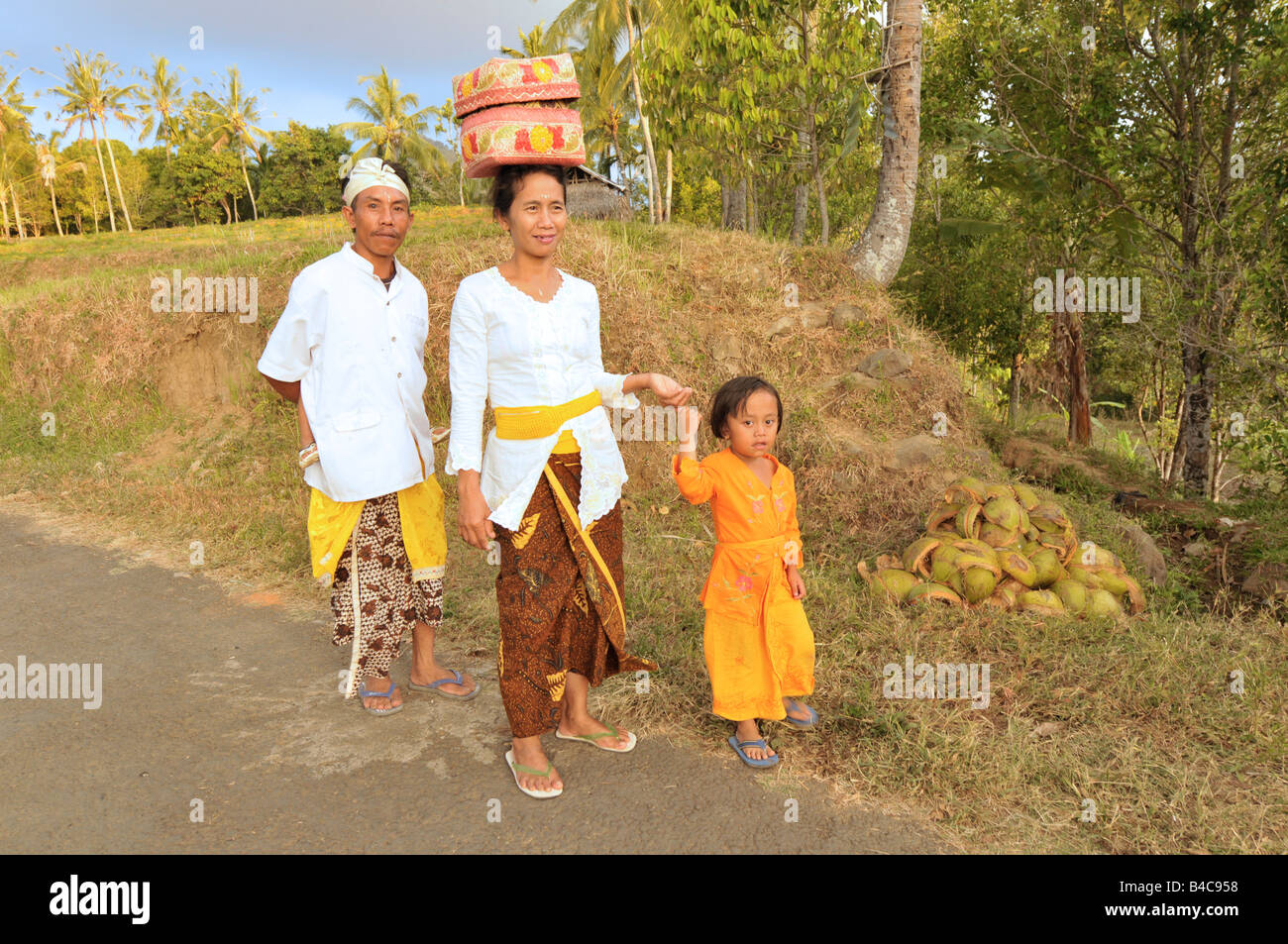 Balinese family coming back from temple to thier home,Bebetin, Bali ...
