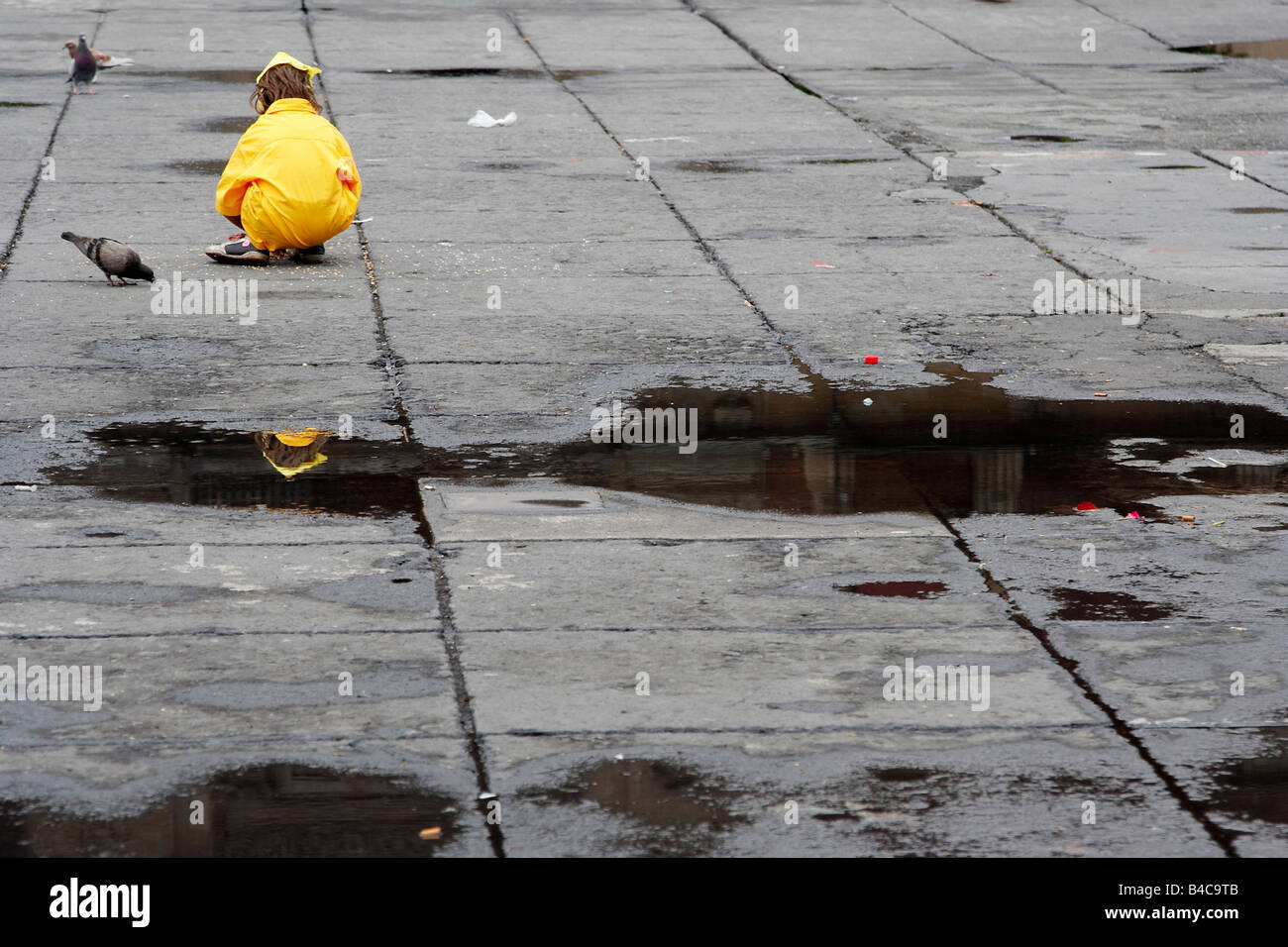 Child playing near puddle Stock Photo - Alamy