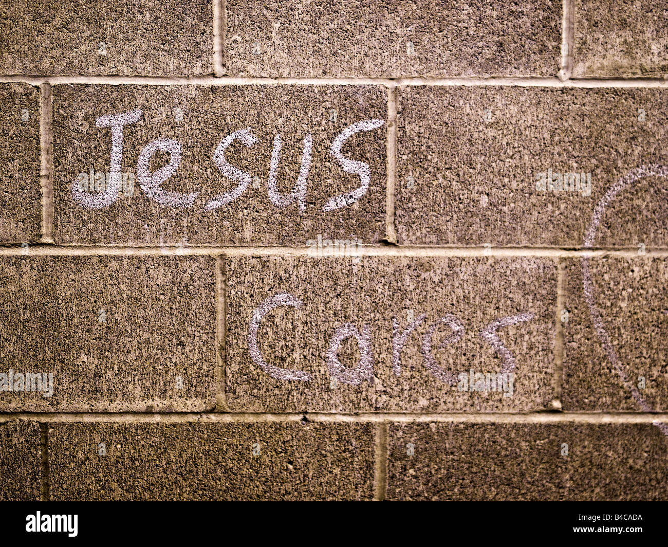 A cinder brick a wall with graffiti that reads Jesus cares Stock Photo ...
