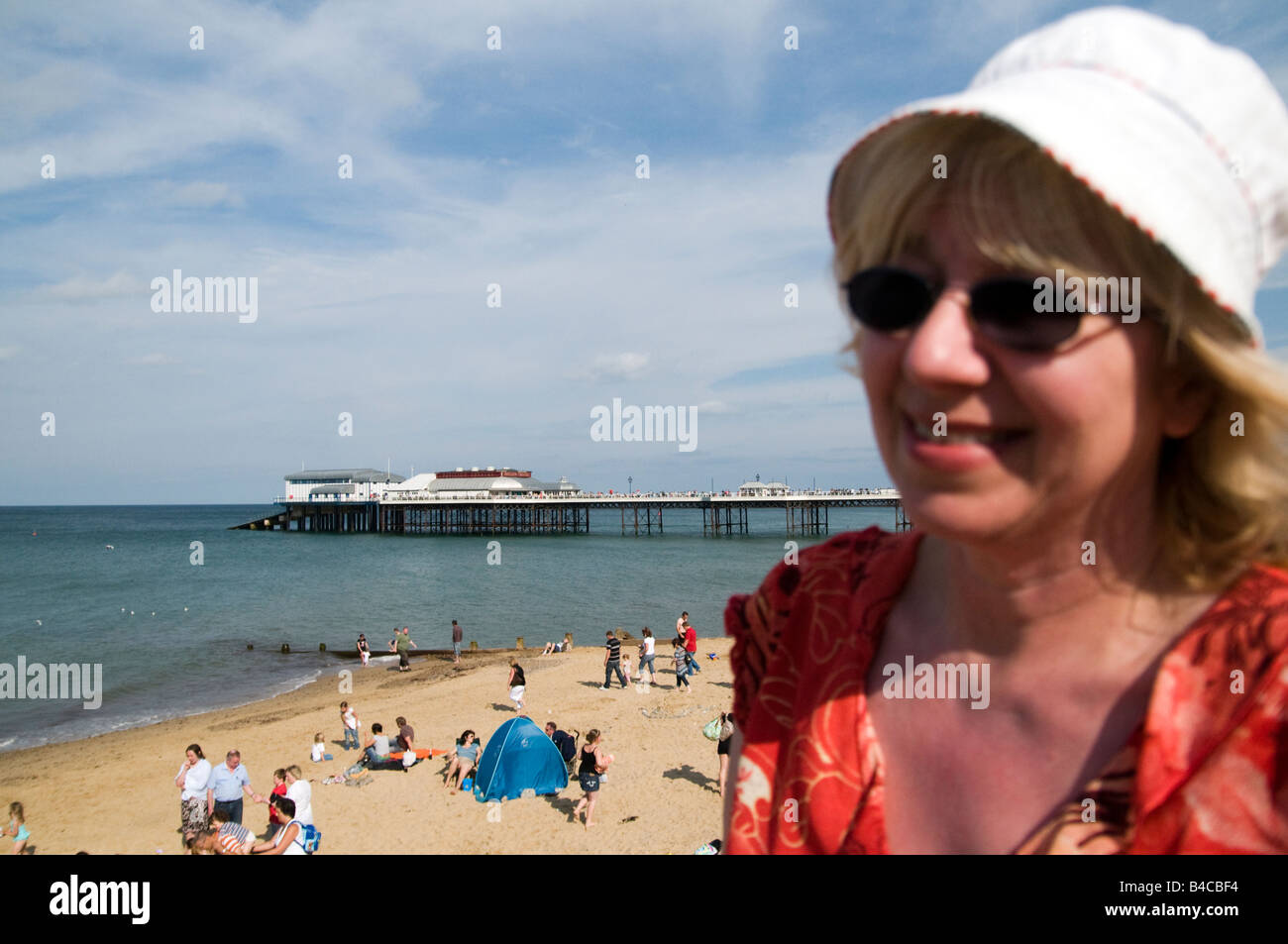 Smiling middle aged woman on holiday at British seaside with Cromer ...