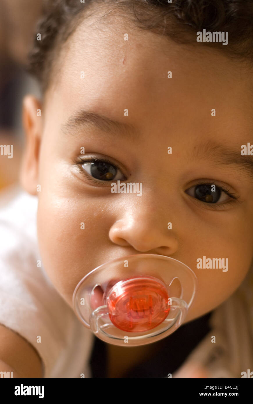 A portrait of a little Latin toddler with his red pacifier Stock Photo ...