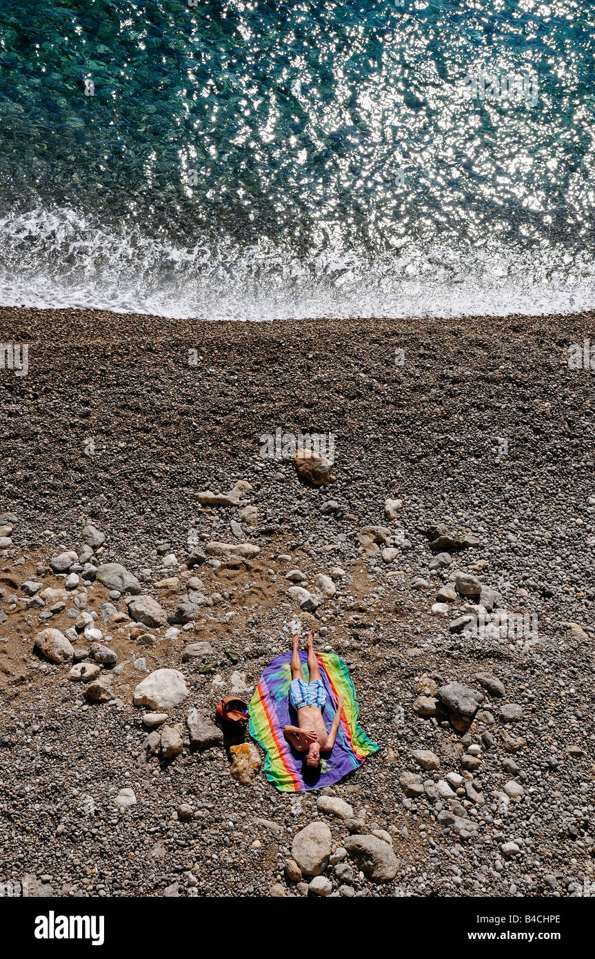 Man sunbathing on pebble beach hi-res stock photography and images - Alamy