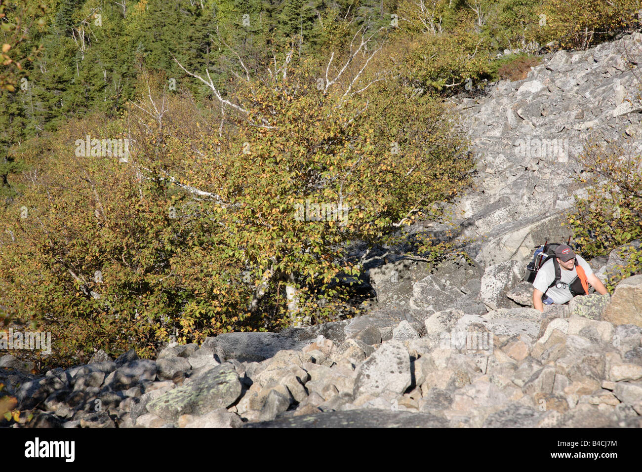 Hikers make their way up a talus field on the side of Whitewall ...