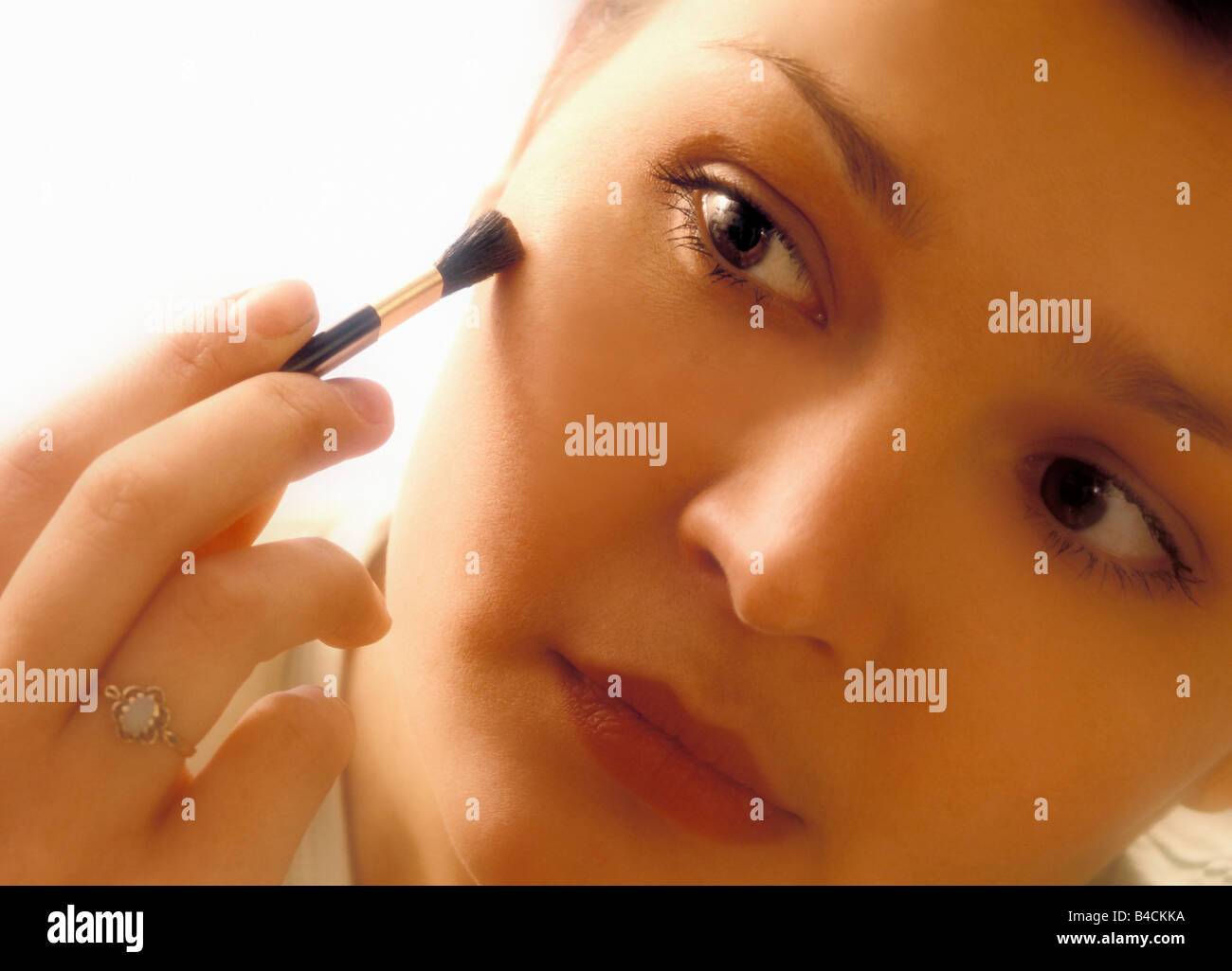 Young woman applying make up by brush Stock Photo - Alamy