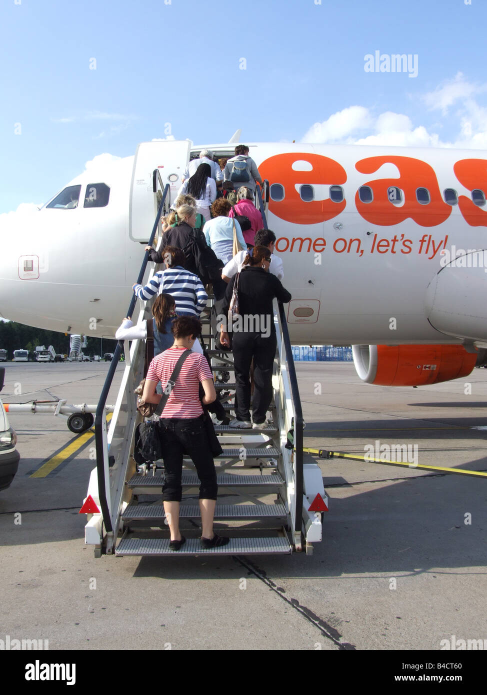 passengers in queue getting on easy jet plane Stock Photo - Alamy