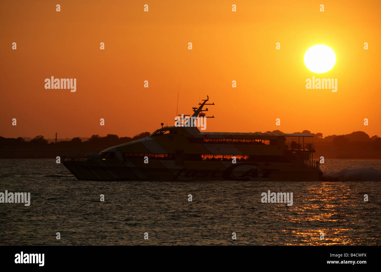 City of Portsmouth, England. Silhouetted sunset view of the Fast Cat ...