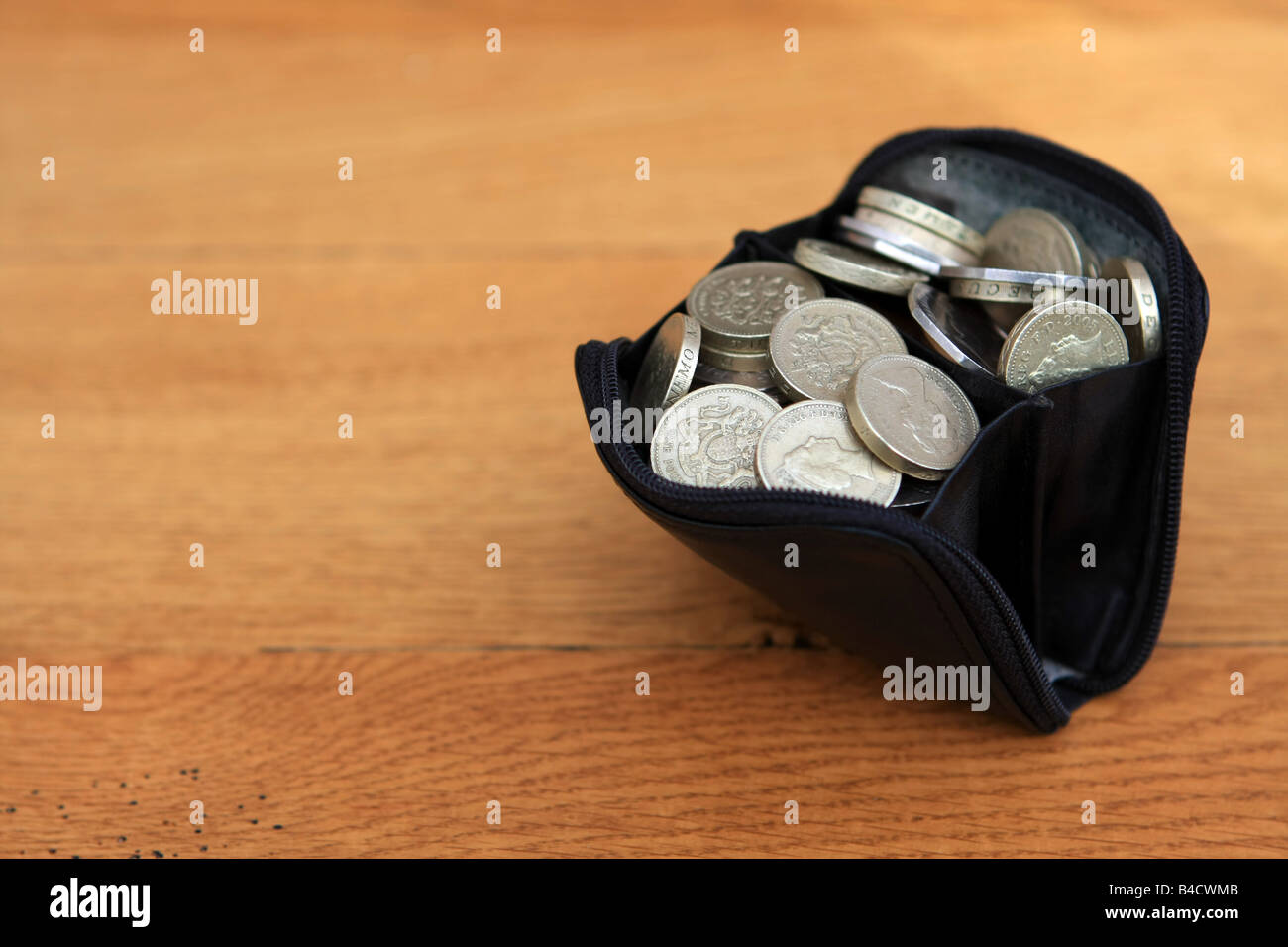 coins filling a purse Stock Photo - Alamy
