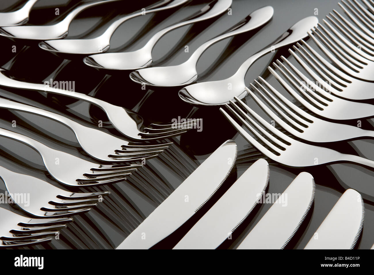 Silver Stainless Steel Cutlery Set on a Graduated Black Background With ...