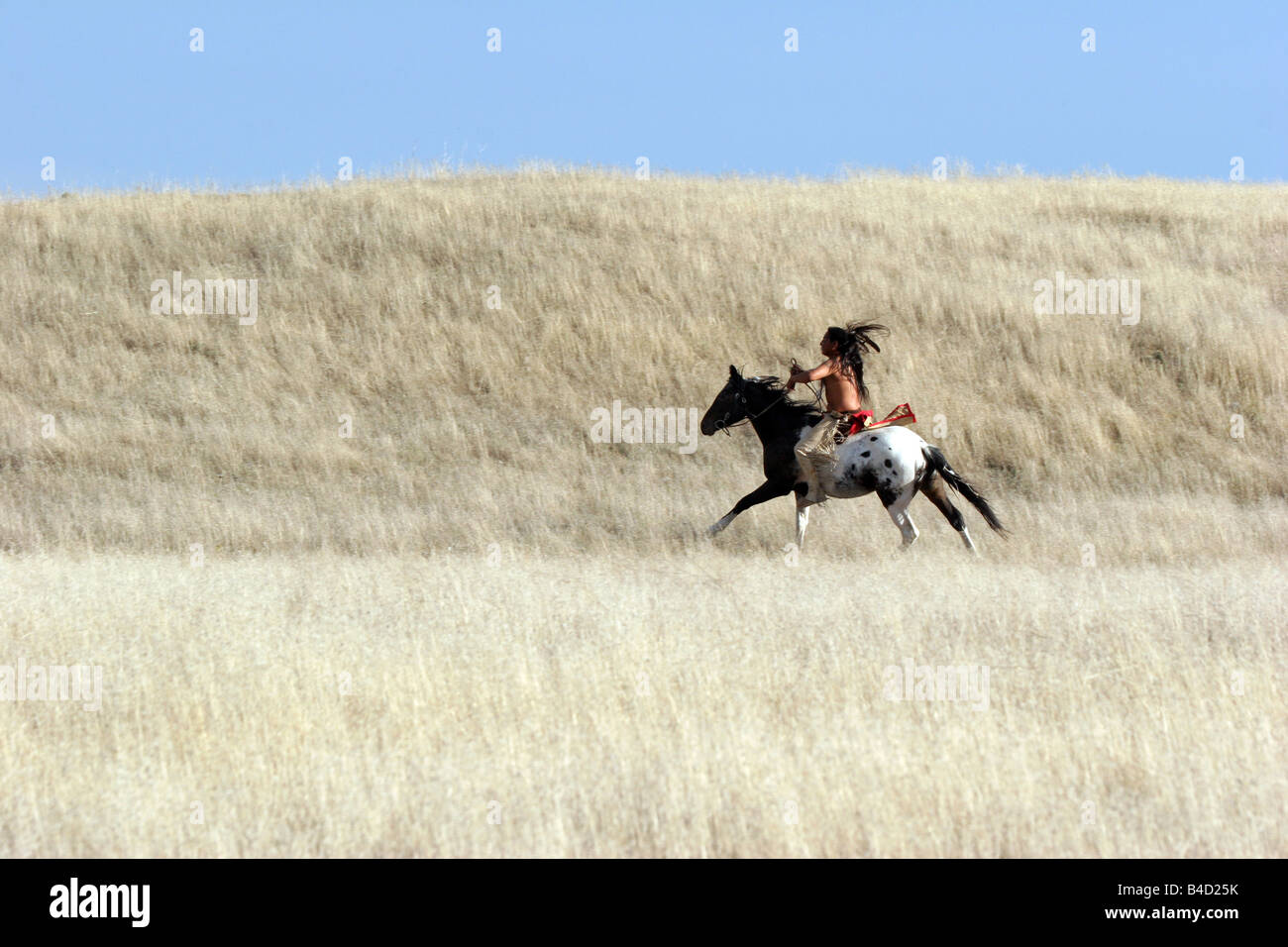 A Native American Lakota Sioux Indian riding horseback on the prairie ...