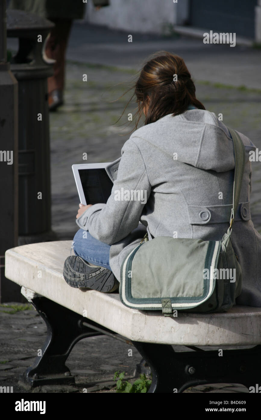 woman on bench working on laptop in town Stock Photo - Alamy