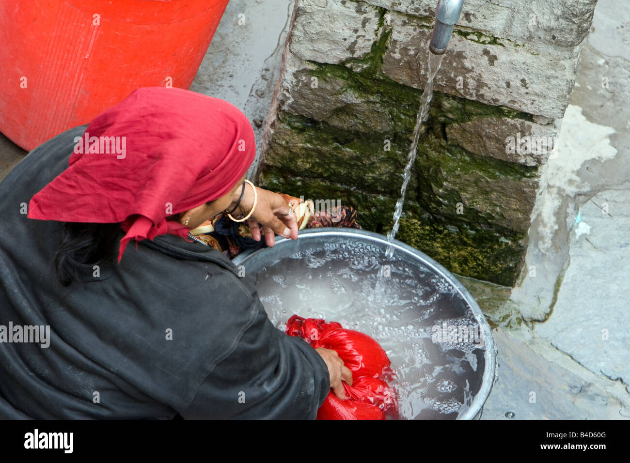 Woman washing clothes in leh Stock Photo - Alamy