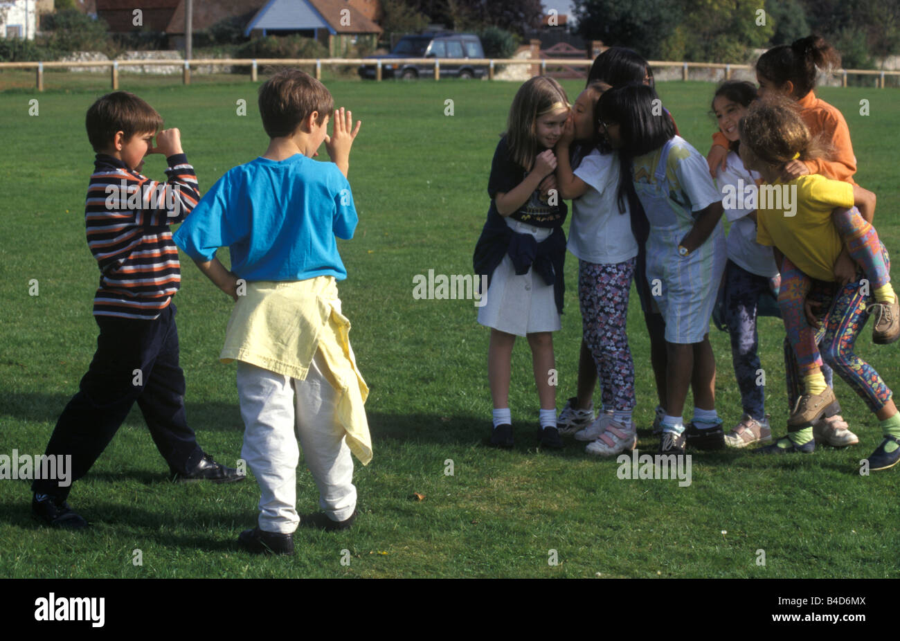 2 boys taunting a group of girls Stock Photo - Alamy