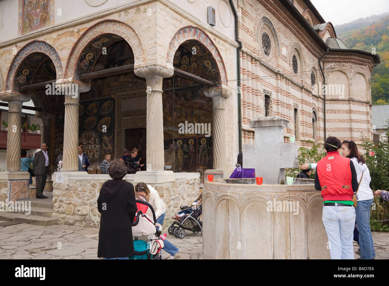 People outside church by holy fountain in 14th century fortified ...
